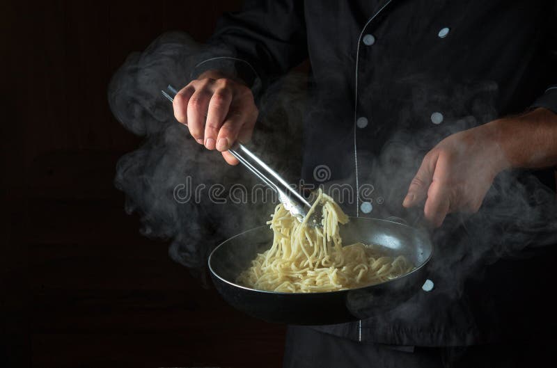 Cooking Spaghetti in a Frying Pan in the Hands of a Chef. Space for ...