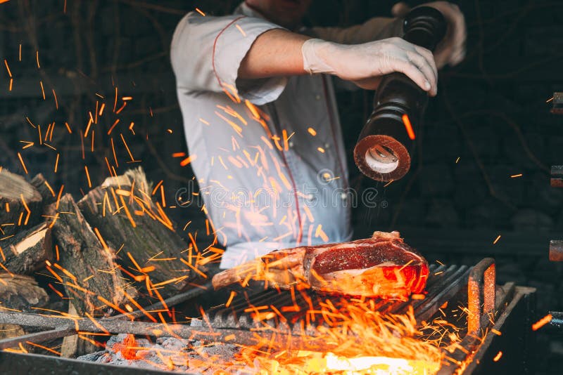 Cooking Steak in a Stone Oven. Chef Pepper the Steak on Fire. Stock ...