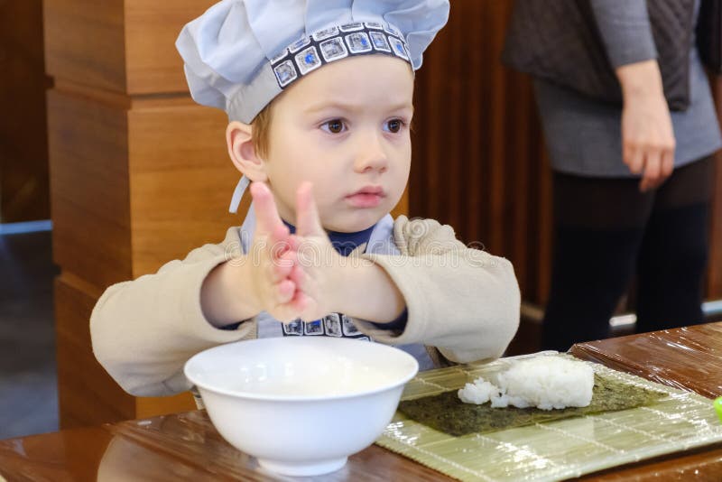 Cooking of Traditional Sushi Rolls. the Boy is Dressed As a Cook. Stock ...