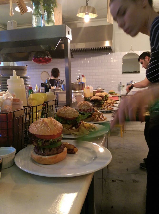 Cooks Preparing Burgers in a Restaurant Kitchen Editorial Stock Image ...