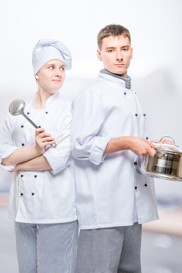 Cooks in Suits with a Saucepan and a Ladle Posing Against the Backdrop ...