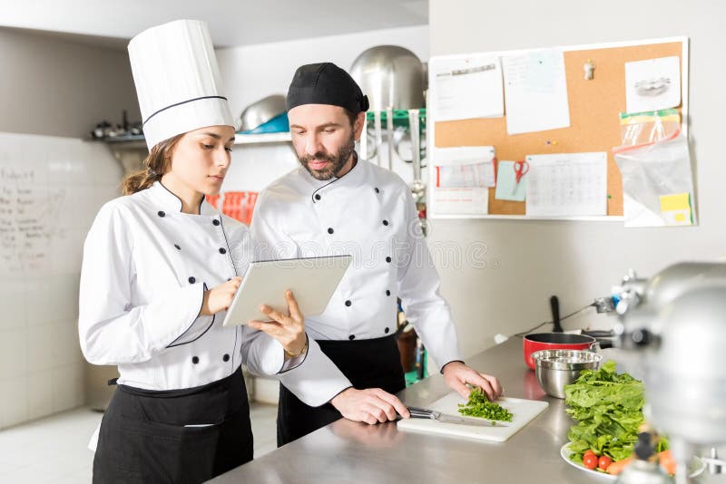 Cooks Using Tablet Computer in Restaurant Kitchen Stock Photo - Image ...