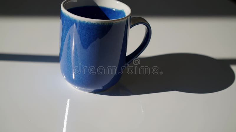 Cool Ceramic Blue Mug Projecting Dramatic Shadow Across Pristine White ...