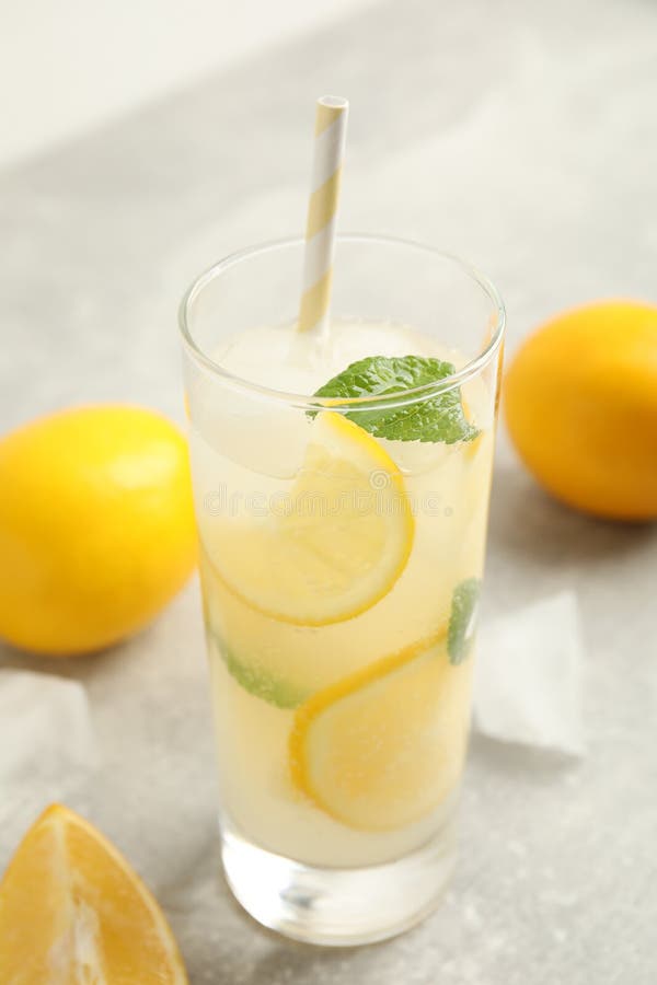 Cool Freshly Made Lemonade, Ice Cubes and Fruits on Grey Table Stock ...
