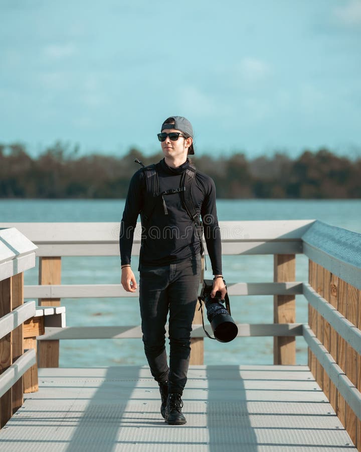 Cool Male Photographer Walking on a Boardwalk, Vertical Shot Stock ...