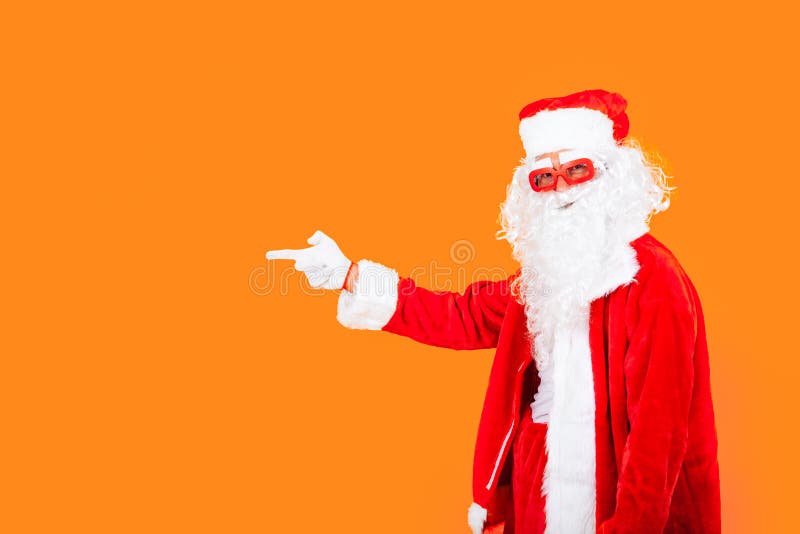 Cool Modern Santa Claus on Orange Background Pointing To the Copy Space ...