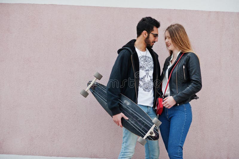 Cool Multiracial Couple Posing Against Pink Wall with Longboard Stock ...