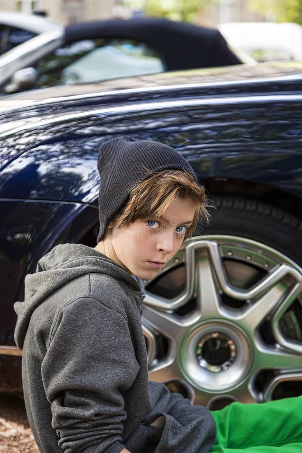 Cool Teenage Boy Sitting in Front of a Rim of Wheel Stock Photo - Image ...