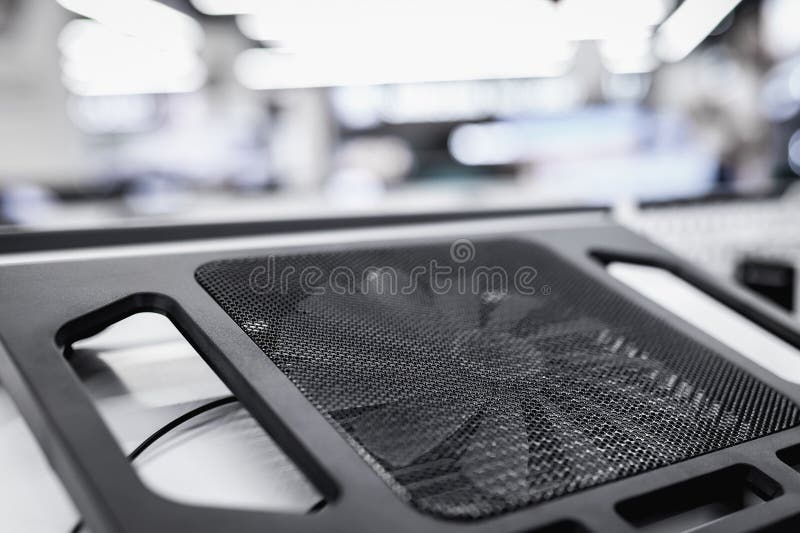 A Cooling Pad or Stand with a Fan for a Laptop Stands on a Shelf in a ...