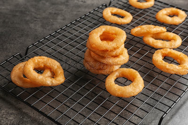 Cooling Rack with Tasty Onion Rings on Table , Closeup Stock Photo ...