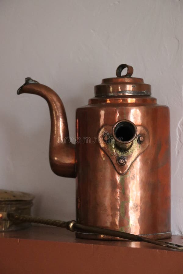 Shiny Orange Copper Kettle with Tall Curved Spout on Brown Mantel ...