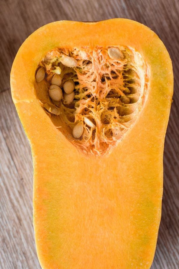 Core with Seeds Cut Pumpkin in Half on the Background of Wooden Texture ...