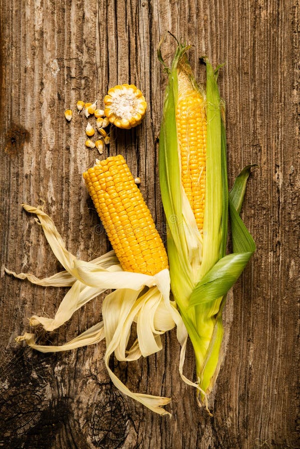 Corn cobs on wooden table stock photo. Image of green - 167477796