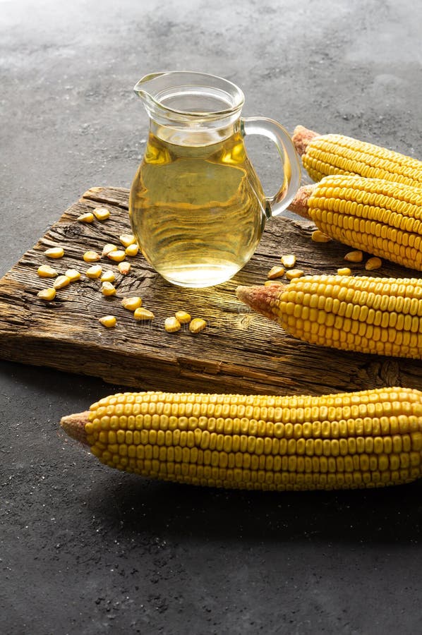 Corn Oil in Glass Bowl with Dried Ripe Corn Cobs on Dark Rustic Table ...
