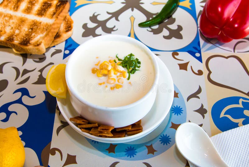 Corn Soup with Lime, Spoon, Crackers and Bread Served in Dish Isolated ...