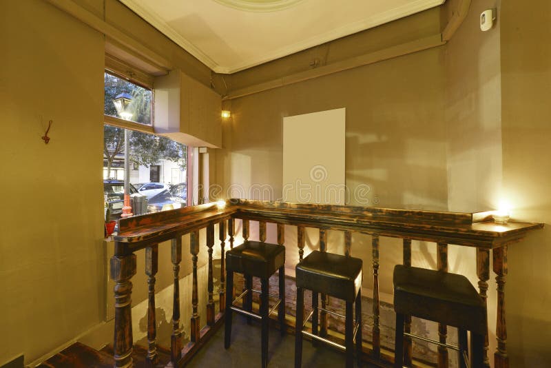 Corner of a Bar with a Wooden Balustrade and High Upholstered Stools ...