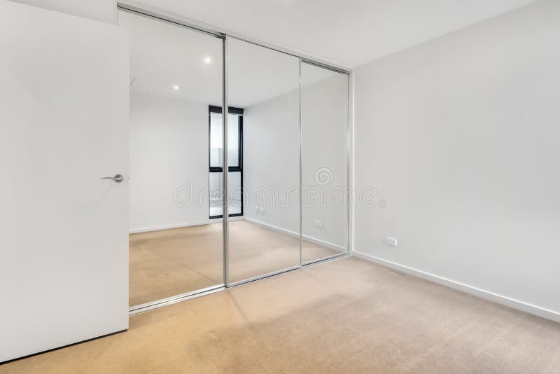 Corner of an Empty Room with White Walls and a Wardrobe with Mirror ...
