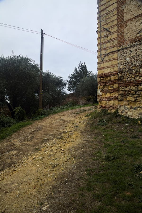 Corner of a Fortification Next To a Dirt Path and a Olive Tree Grove on ...