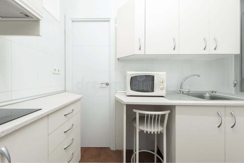 Corner of a Humble Conventional Kitchen with White Cabinets and ...