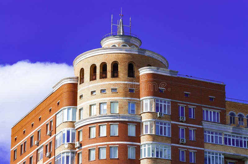 The Corner and Top of a Brick High-rise Building Against a Blue Sky ...