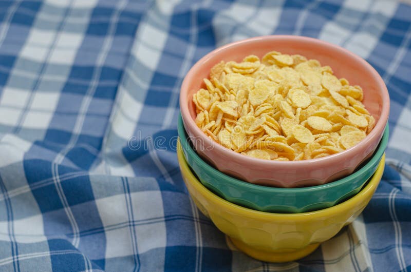 Cornflakes and Three Bowls of Different Colors, on a Plaid Napkin in ...