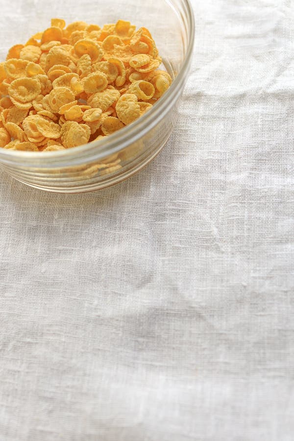 Cornflakes in a Transparent Glass Plate on a Light Rustic Tablecloth ...