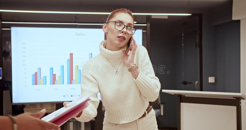 Corporate Woman Multitasking, Talking on Phone in Front of Sales Data ...
