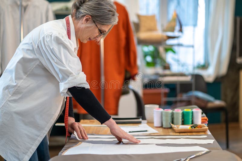 Profile of Woman Laying Out Pattern on Table Stock Photo - Image of ...