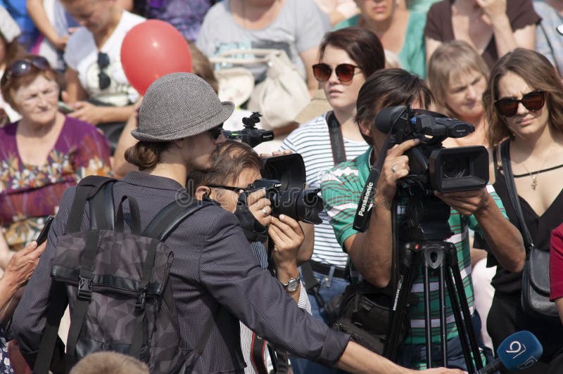 Correspondent and Camera Working in Crowd. TV Reporter Working in ...
