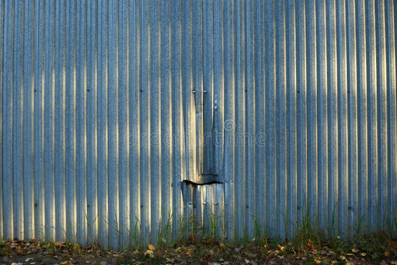 Corrugated Metal Fence with a Dent and a Ragged Hole Stock Photo ...
