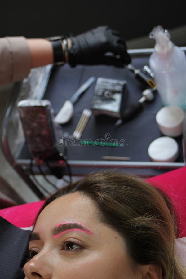 Cosmetologist Applying Permanent Make Up Eyebrows for a Client in a ...