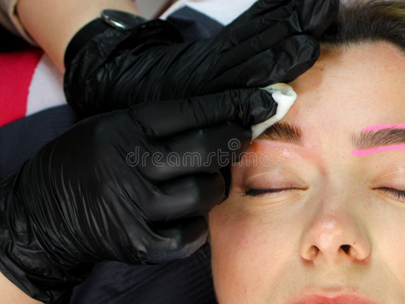 Cosmetologist Applying Permanent Make Up Eyebrows for a Client in a ...