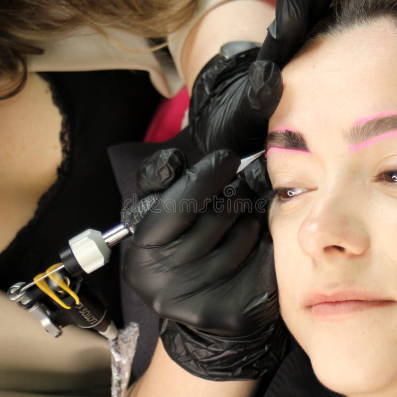 Cosmetologist Applying Permanent Make Up Eyebrows for a Client in a ...