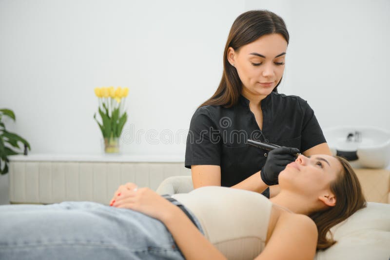 Cosmetologist Doing Permanent Makeup Eyebrows. Care and Beauty Concept ...
