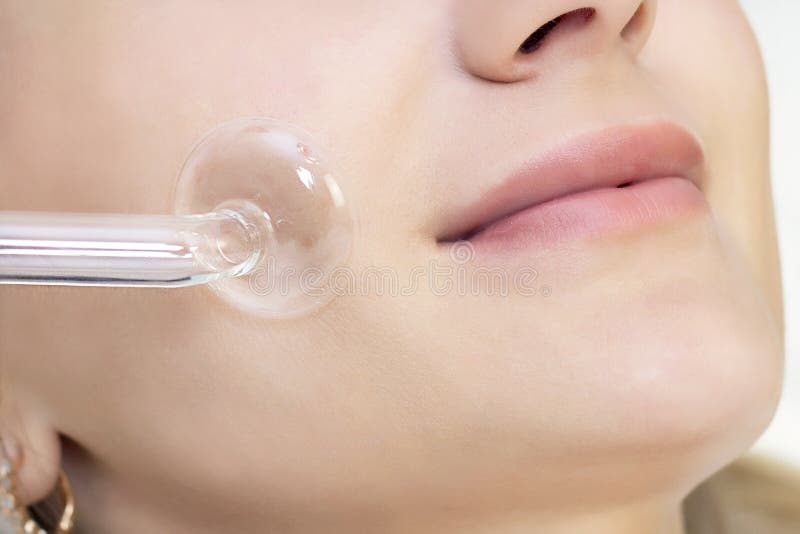 Cosmetologist Performs a Pulse Current Procedure for the Face of a ...