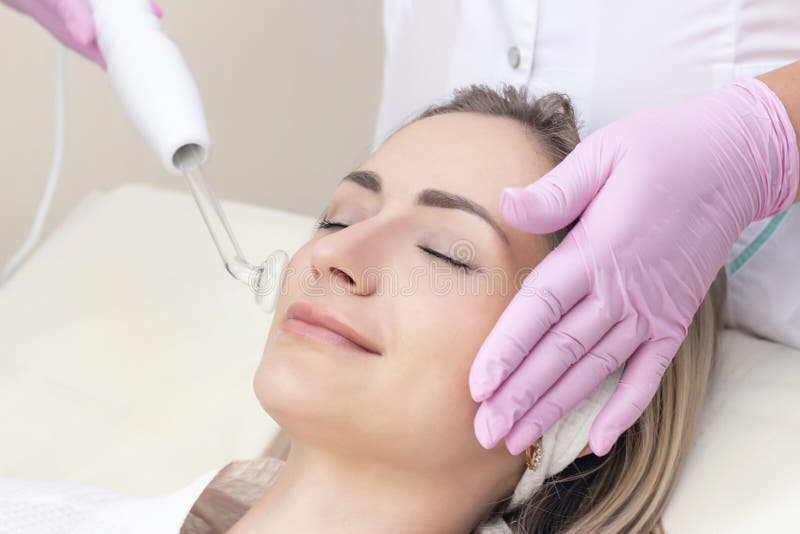 Cosmetologist Performs a Pulse Current Procedure for the Face Stock ...