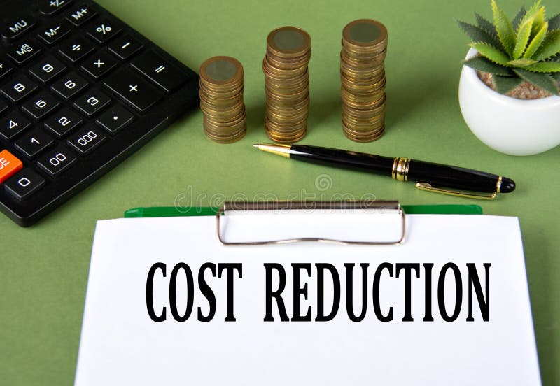 COST REDUCTION - Words on a White Sheet with a Calculator and Stacks of ...