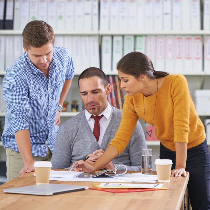 We Could Change this. Three Businesspeople Talking Around a Desk. Stock ...