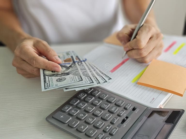 Counting Cash while Preparing a Budget Plan with a Calculator and ...