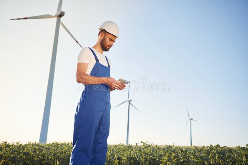 With Notepad. Service Engineer is on the Field with Windmills Stock ...