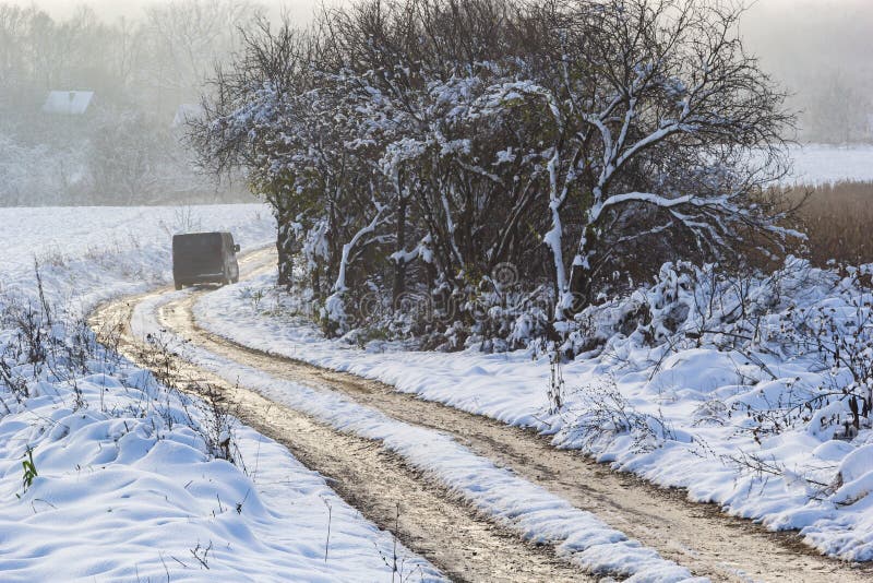 A Country Road through the Forest, a Wet Road with Snow Falling from ...