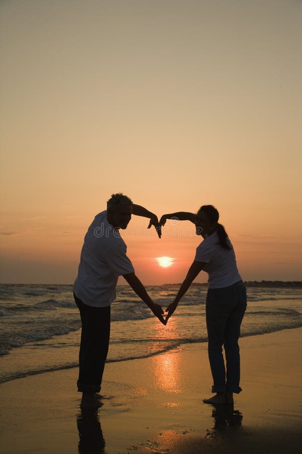 Couple on beach at sunset. stock image. Image of tide - 2046251