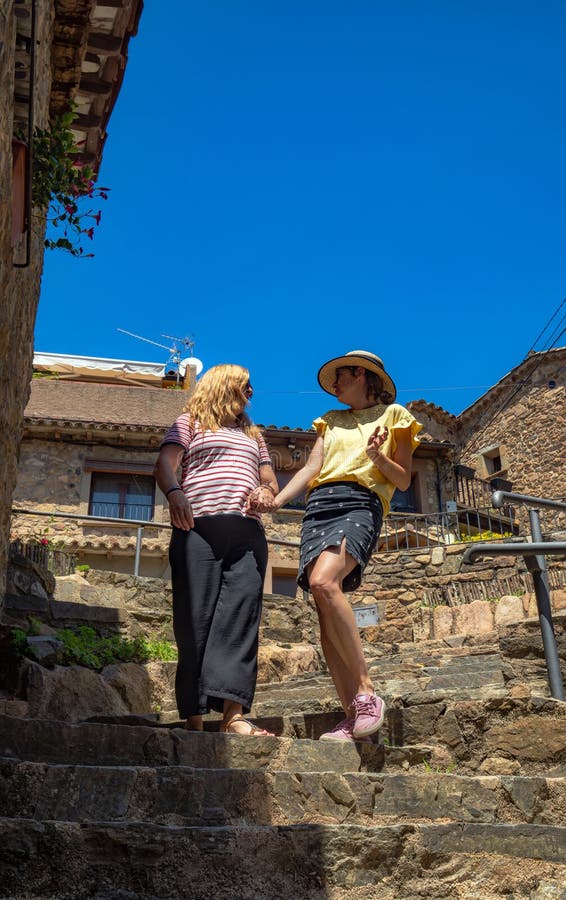 Two Lesbian Friends Holding Hands Walking Down A Staircase In A Rural