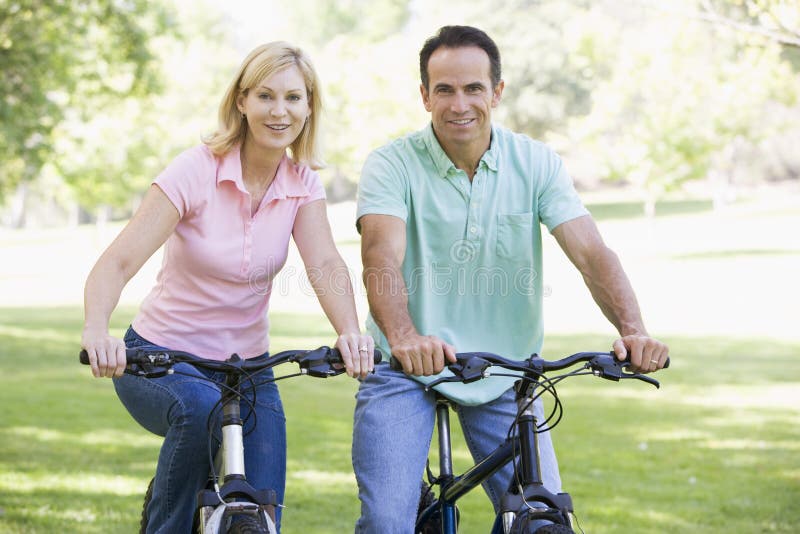 Couple on Bikes Outdoors Smiling Stock Photo - Image of horizontal ...