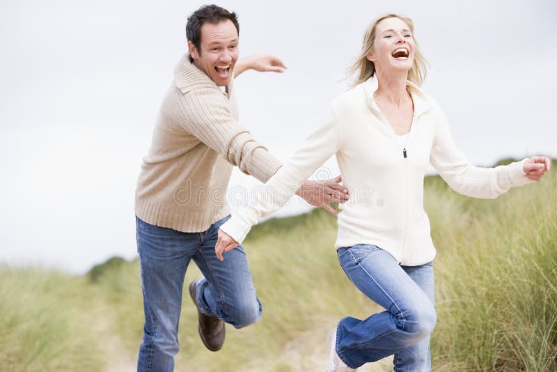 Couple Chasing One Another through Dunes Stock Photo - Image of ...