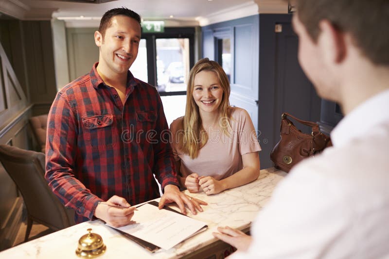 Couple Checking in at Hotel Reception Desk Stock Image - Image of ...