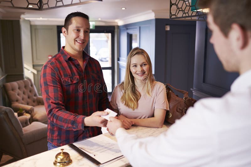 Couple Checking in at Hotel Reception Desk Stock Image - Image of ...