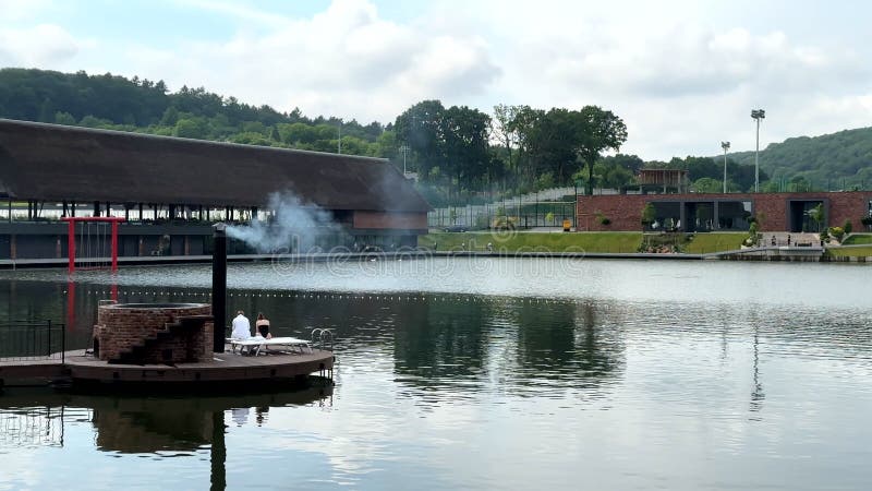 Couple Chilling At Resort Taking Hot Sauna At The Lake Beach Stock