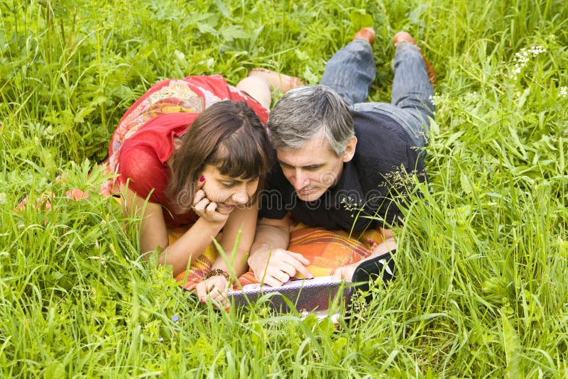 Couple with Computer on Grass Stock Image - Image of outdoors, computer ...