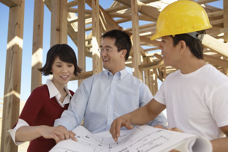 Couple with Contractor at Construction Site Stock Photo - Image of ...